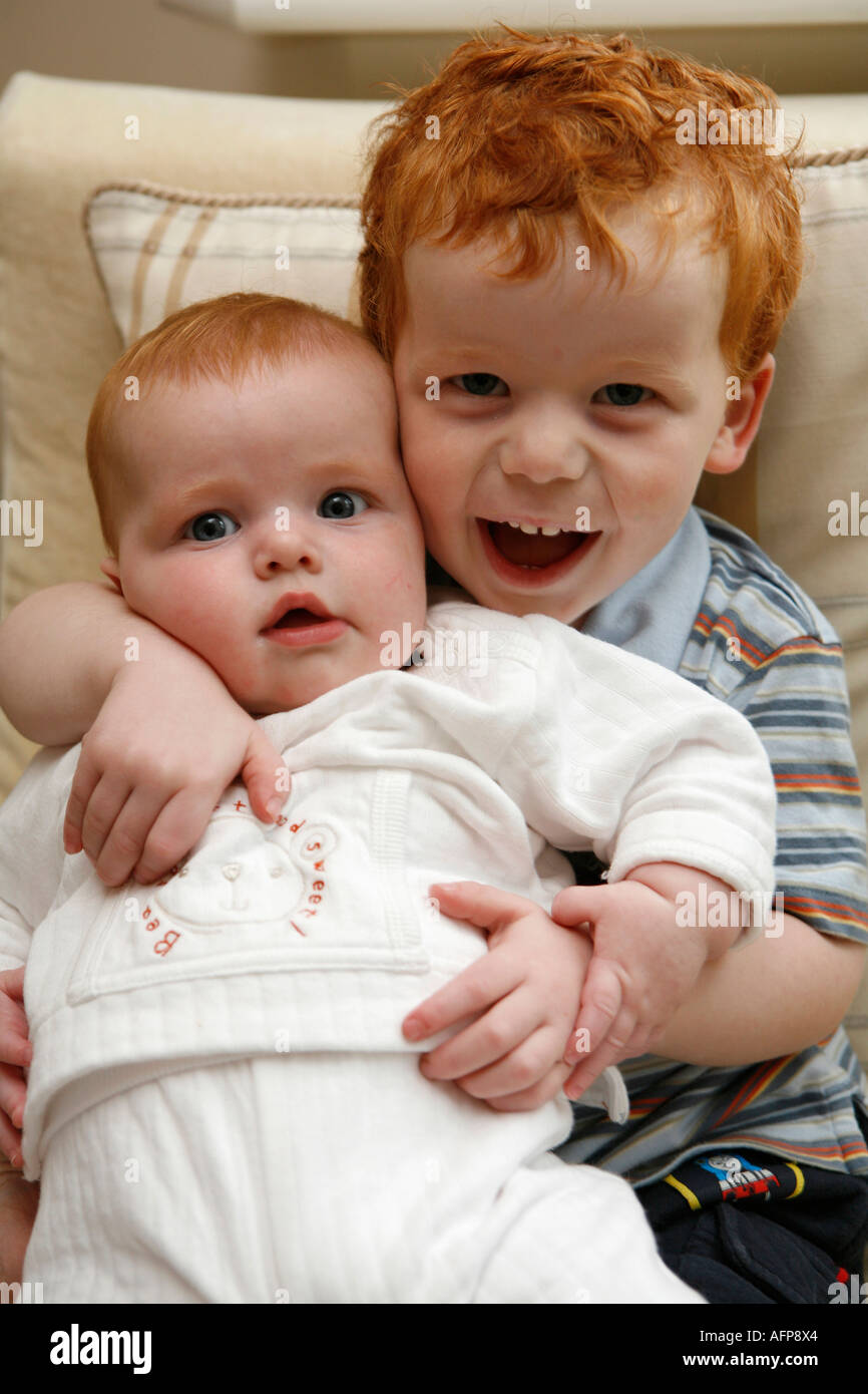 Toddler boy and his baby sister having a cuddle Stock Photo - Alamy