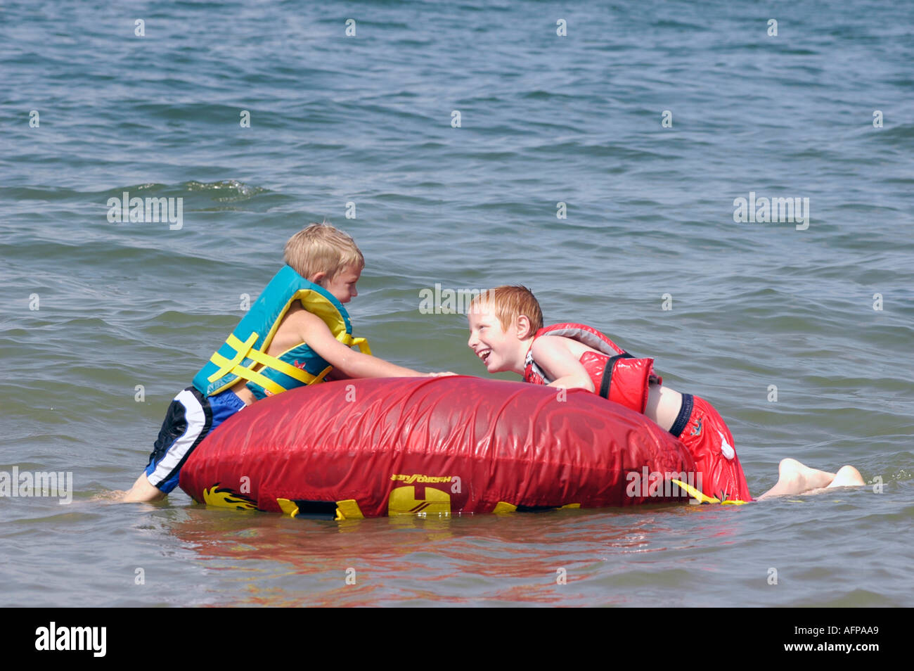 Kids with their inflatable boat at the lake Stock Photo - Alamy