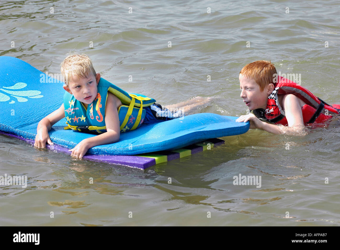 Kids with their inflatable boat at the lake Stock Photo - Alamy