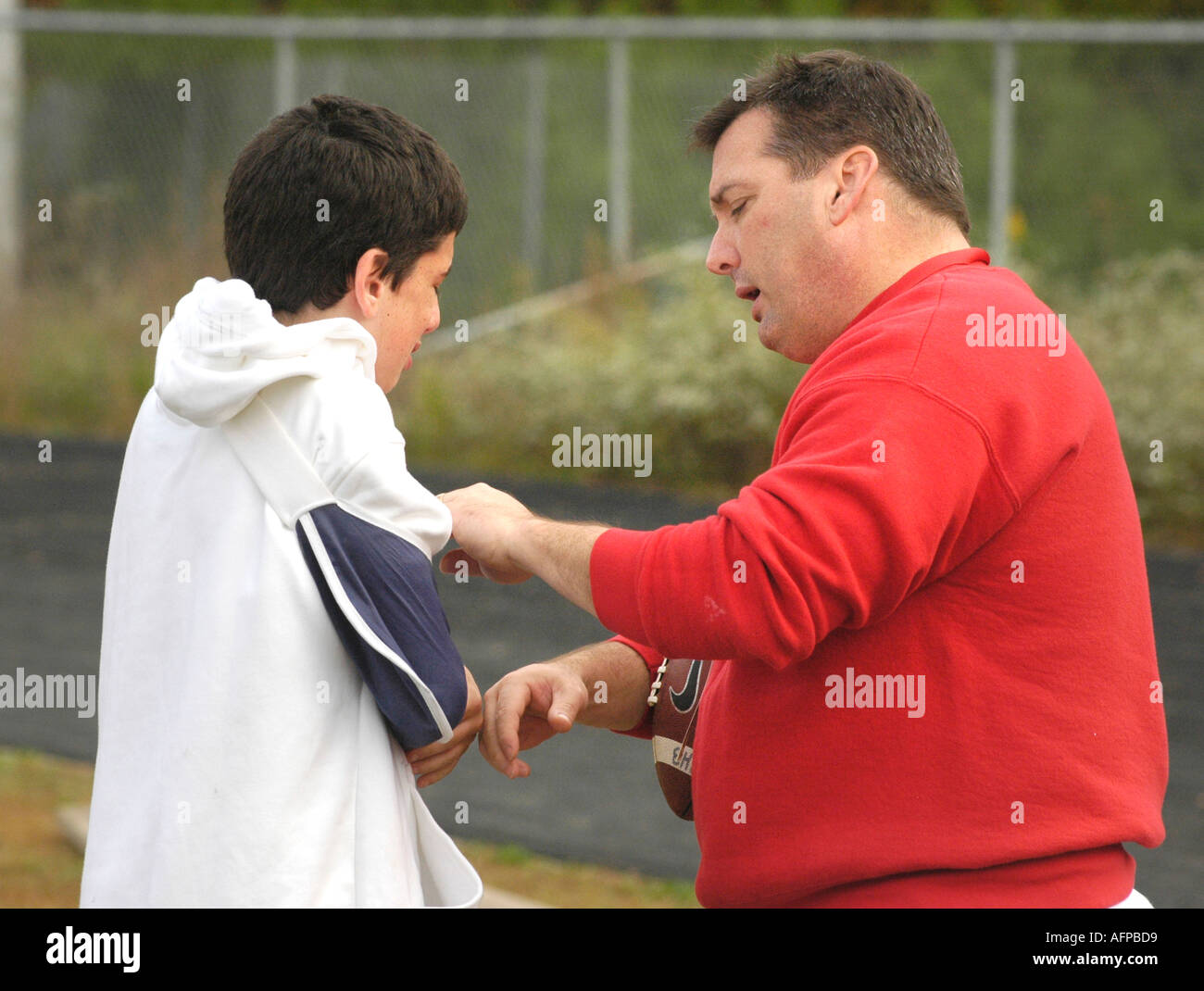 Injured young football player on bench with arm in cast from injury and ...