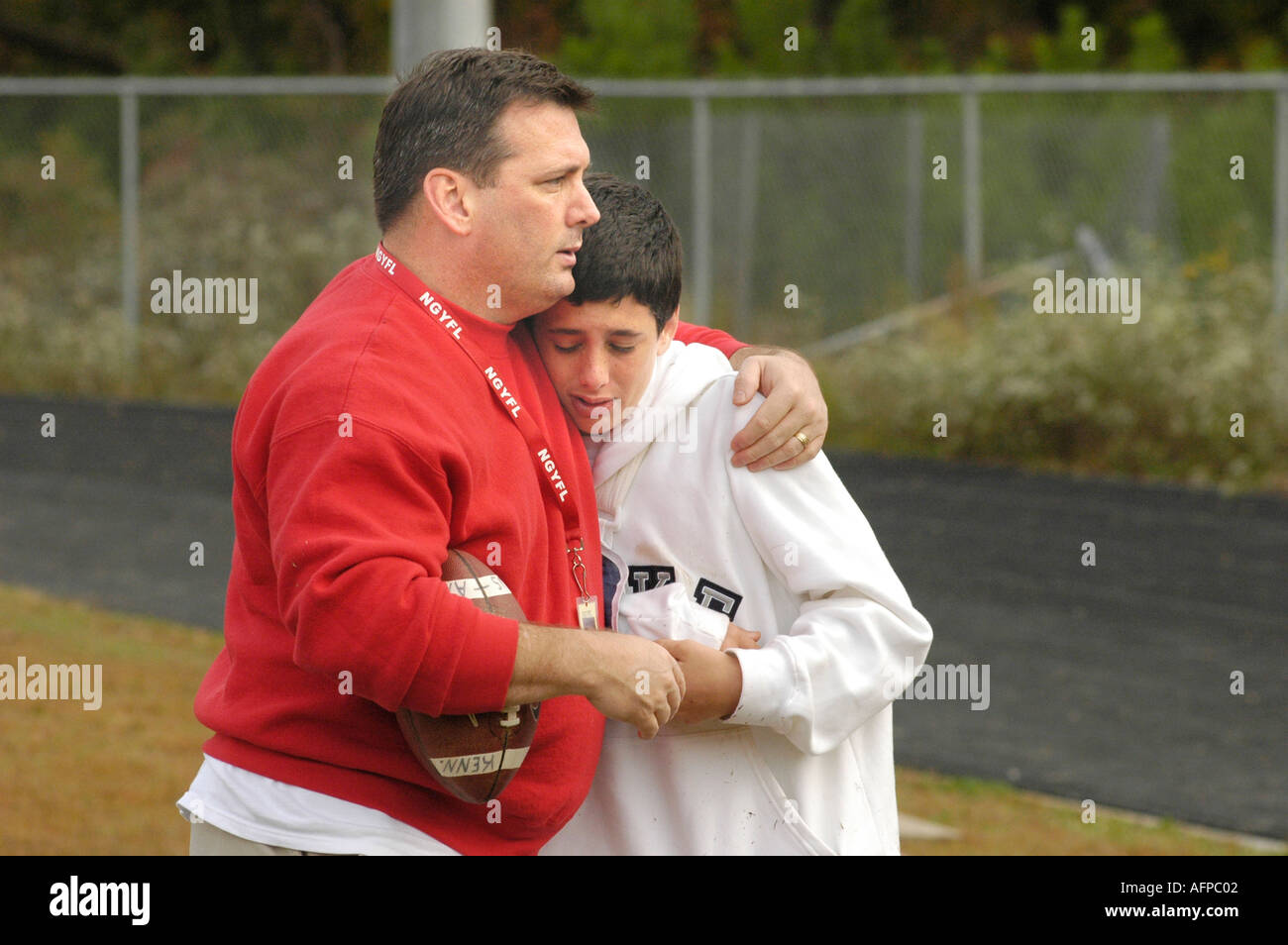 Injured young football player on bench with arm in cast from injury and ...