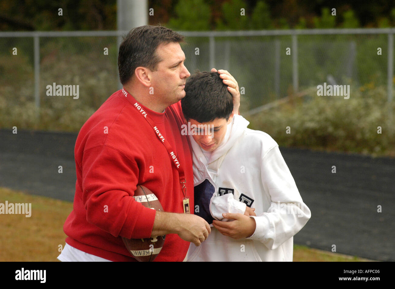 Injured young football player on bench with arm in cast from injury and ...