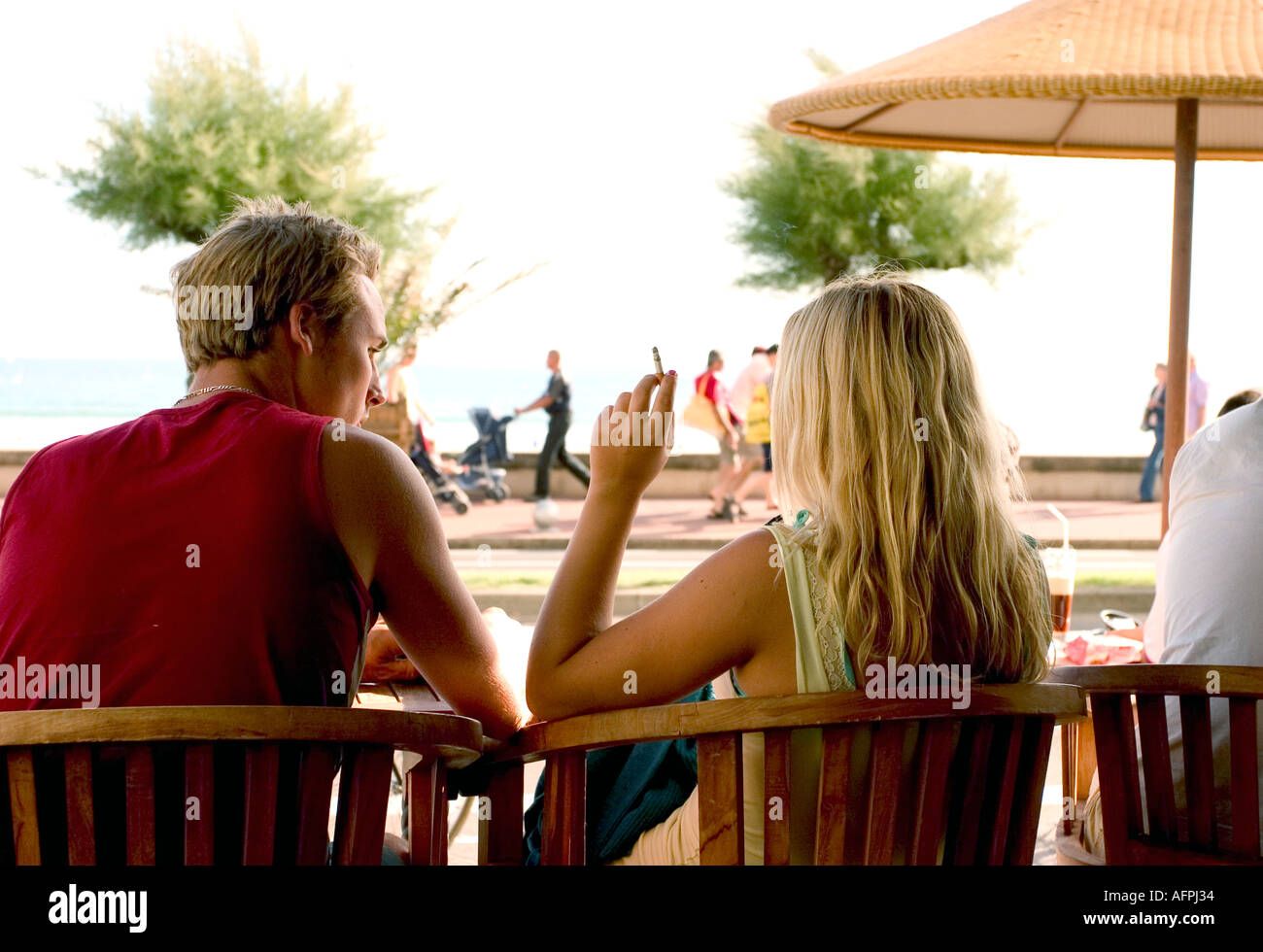 loving couple seating and taking a dring on a bar terrace in front of ...