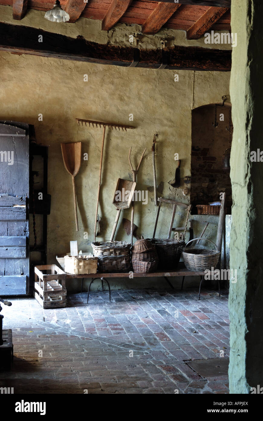 A collection of old fashioned agricultural tools in a farmhouse kitchen ...