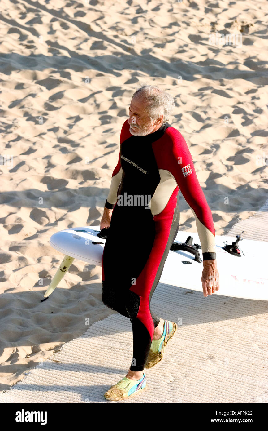 old senior man holding a surfboard back from the waves Stock Photo - Alamy