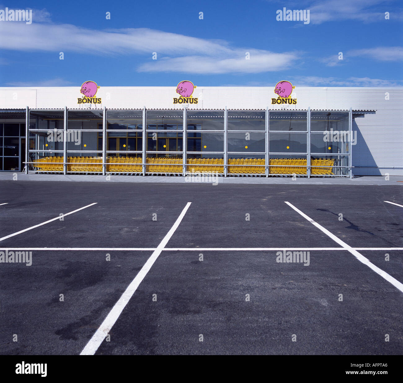 Supermarket car park in Iceland with a row of yellow shopping trolleys ...