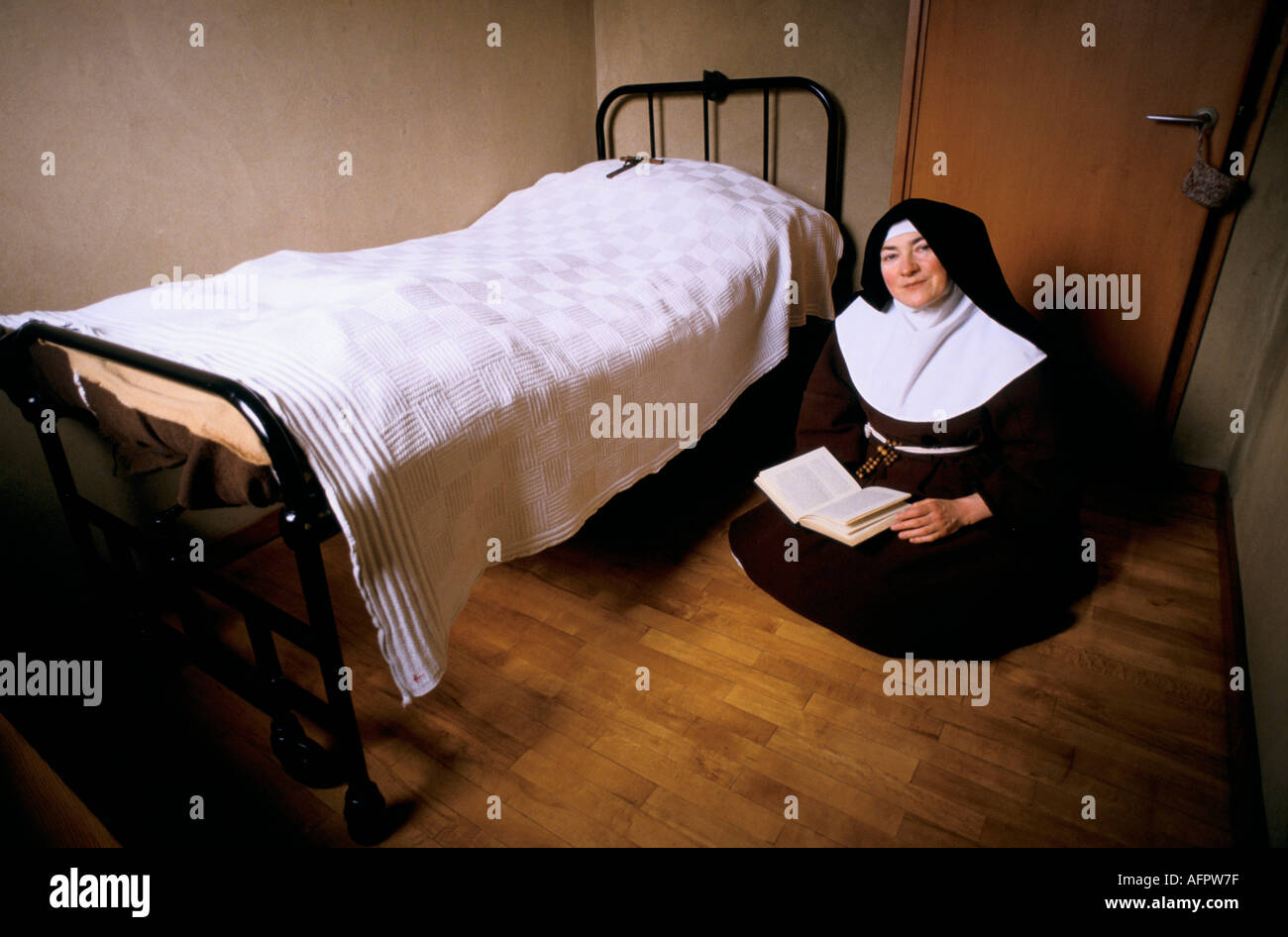 Young nun UK. Sister Colette in her cell reading the bible. Poor Clare ...