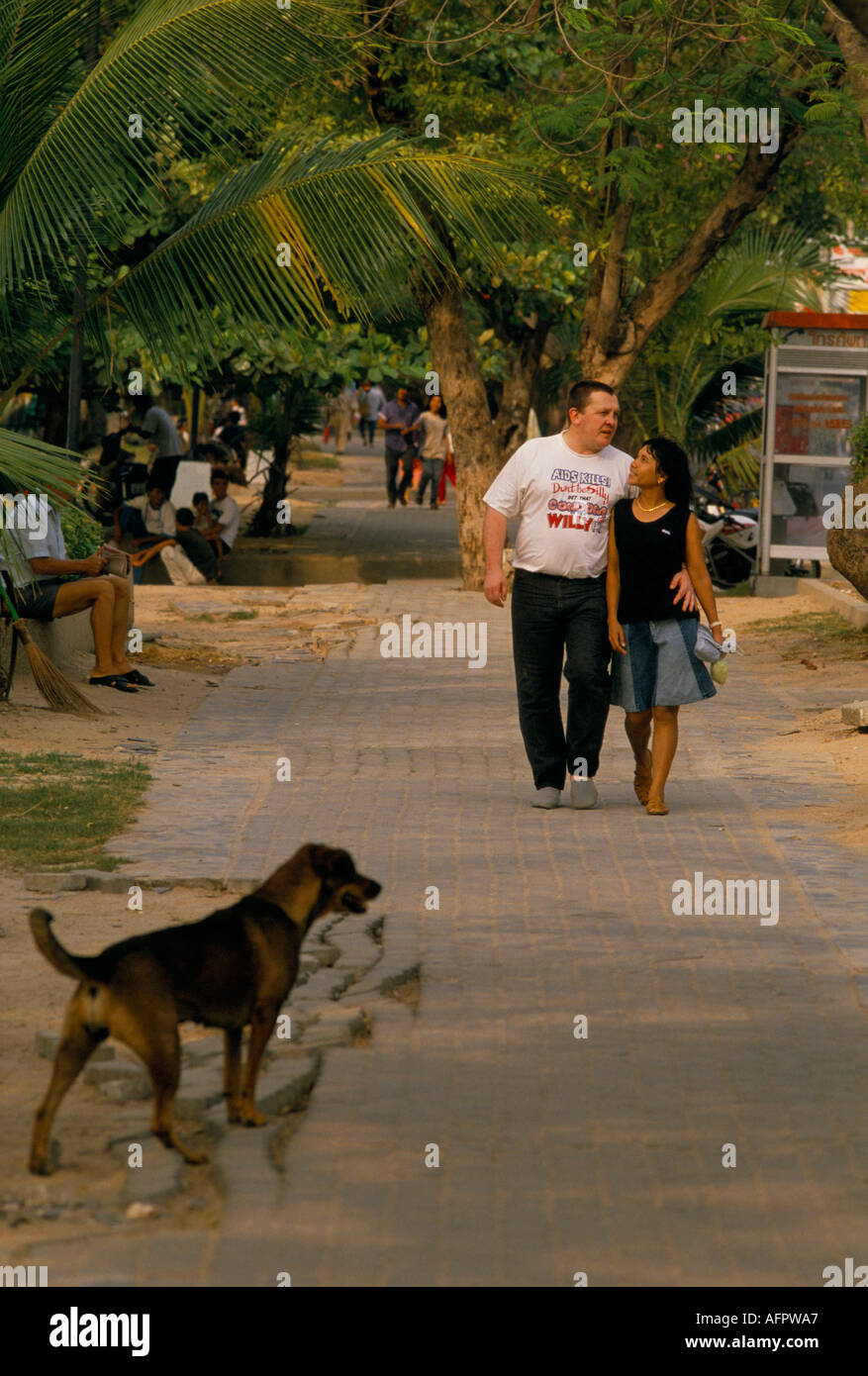 Thai Girl With Male Sex Tourist Who Is Wearing An Aids Awareness T