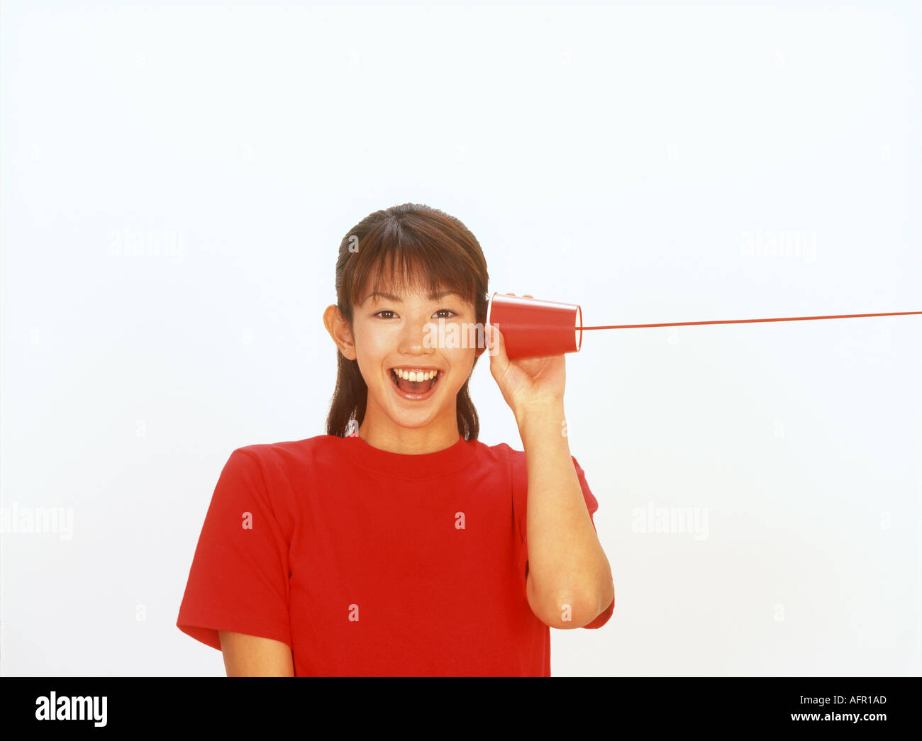 Japanese Woman Listening on String Telephone Stock Photo - Alamy