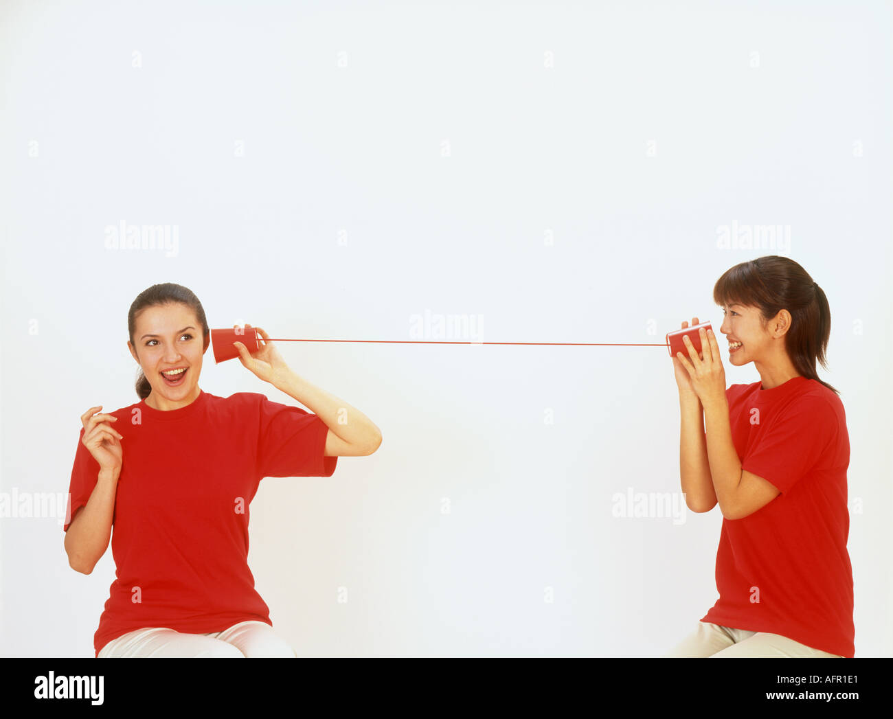 Women on String Telephone Stock Photo - Alamy