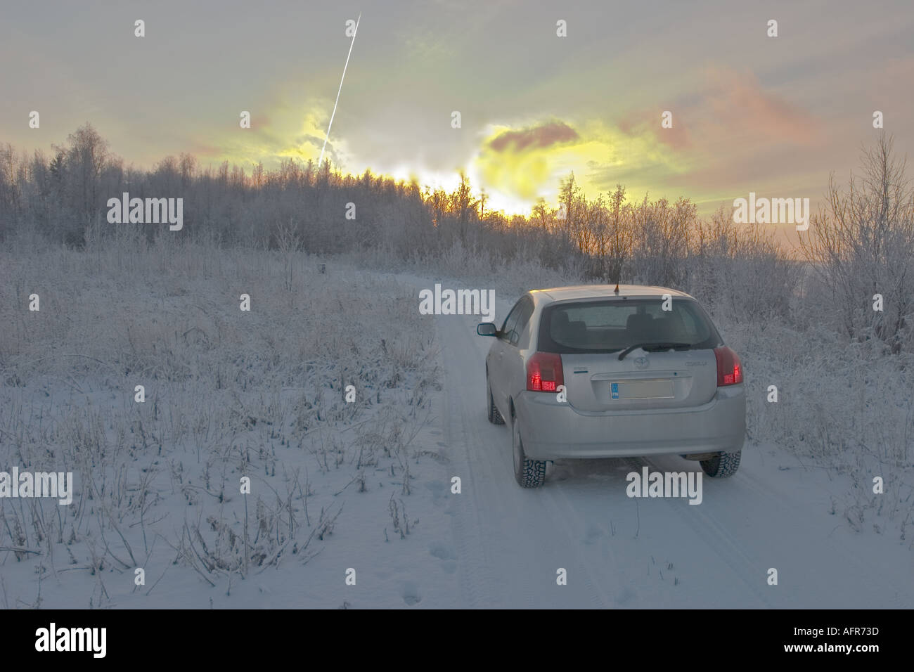 Toyota Corolla Hatchback 2002 model on snowy forest road at sunset ...