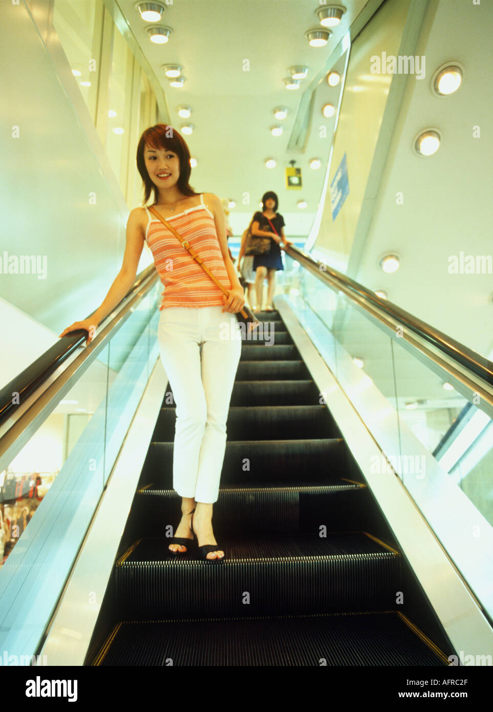 Woman riding on escalator Stock Photo - Alamy
