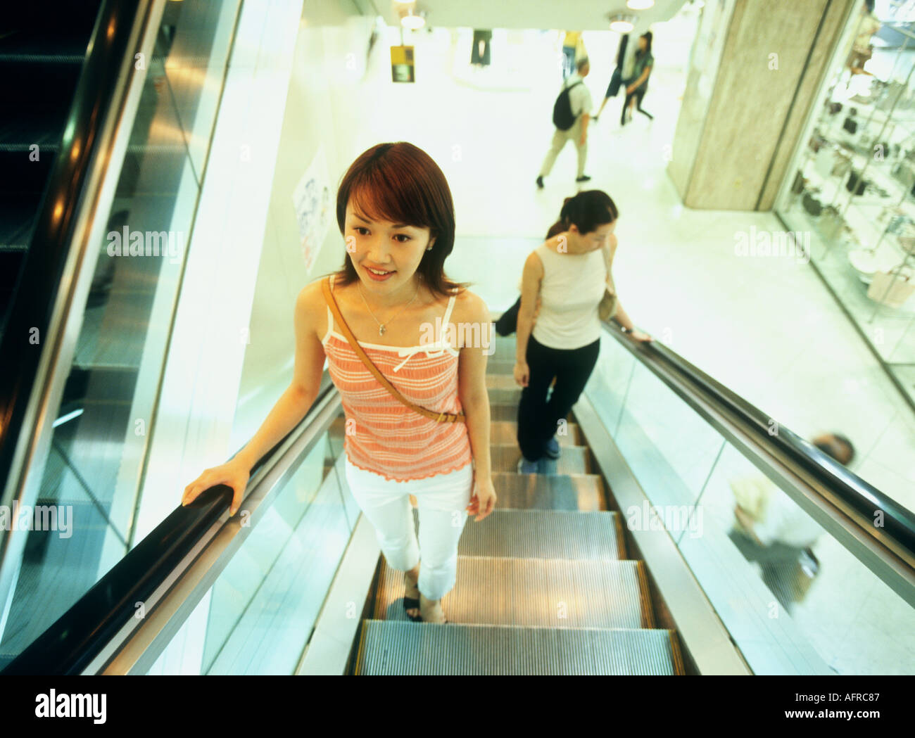 Woman riding on escalator Stock Photo - Alamy