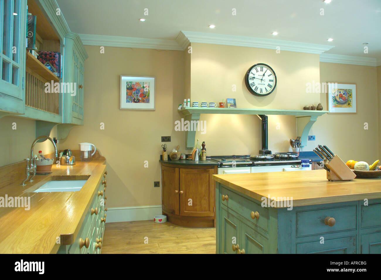Clock over Aga in neutral traditional kitchen with turquoise cupboards ...