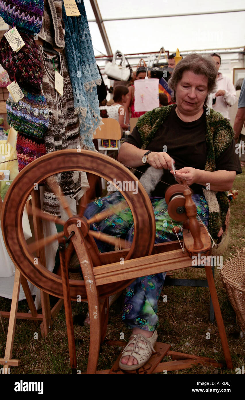 Lady operating a spinning wheel at craft fair Stock Photo - Alamy
