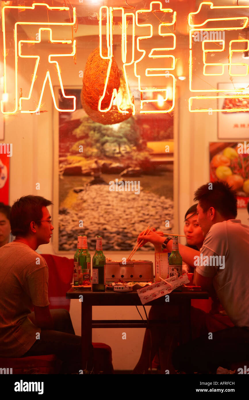 View through restaurant window of people eating, Dongzhimen Nei Dajie ...