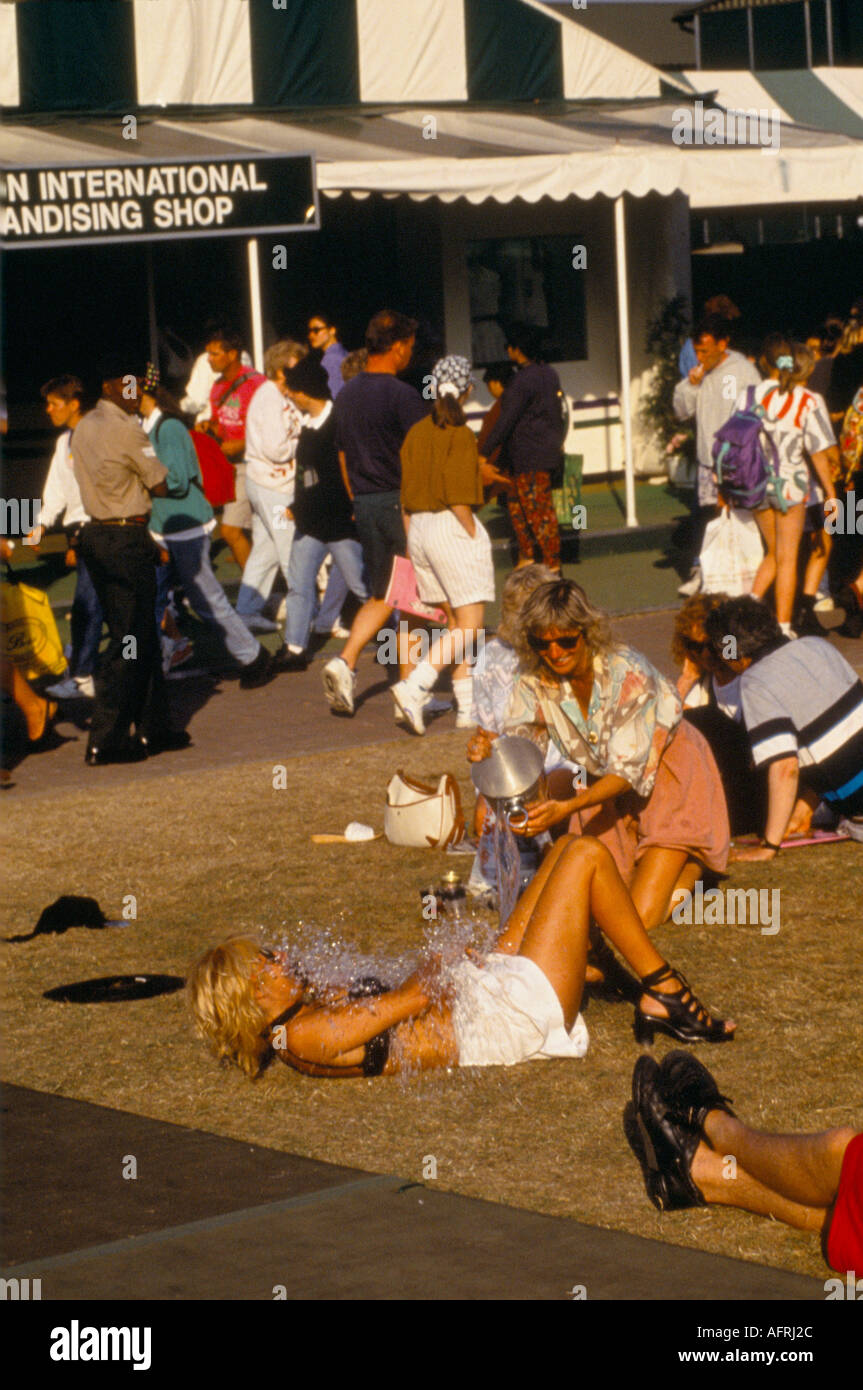Drunk young women at Wimbledon tennis championships, one throws a ...
