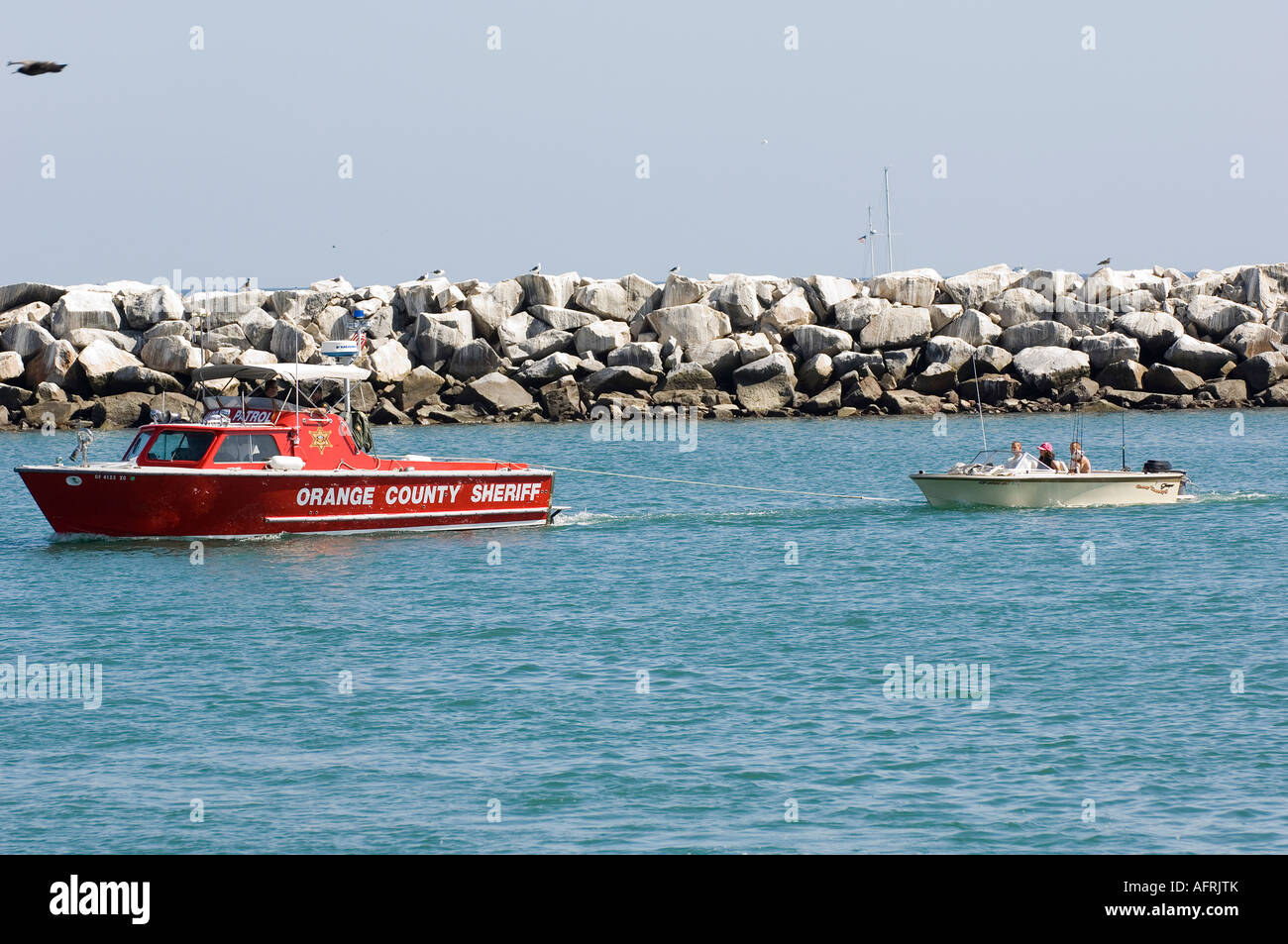 Orange County Sheriff harbor patrol tows a small boat into harbor Stock ...