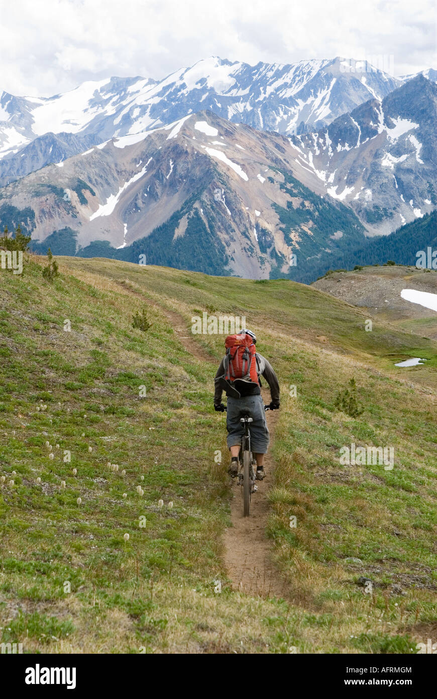 Mountain biker with big pack descending Deer Pass in the Chilcotin ...