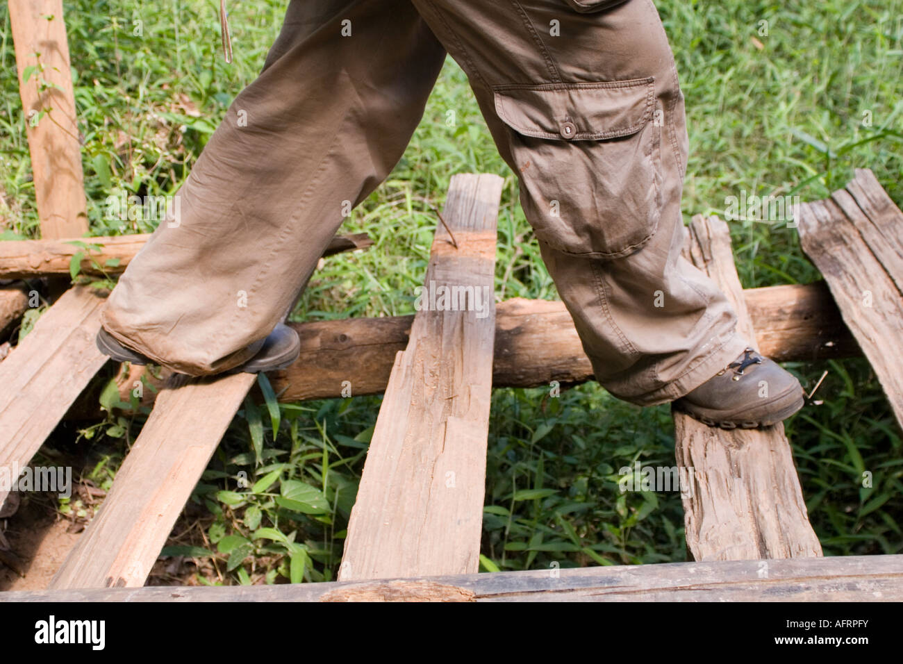 Person walking over rickety bridge Stock Photo - Alamy