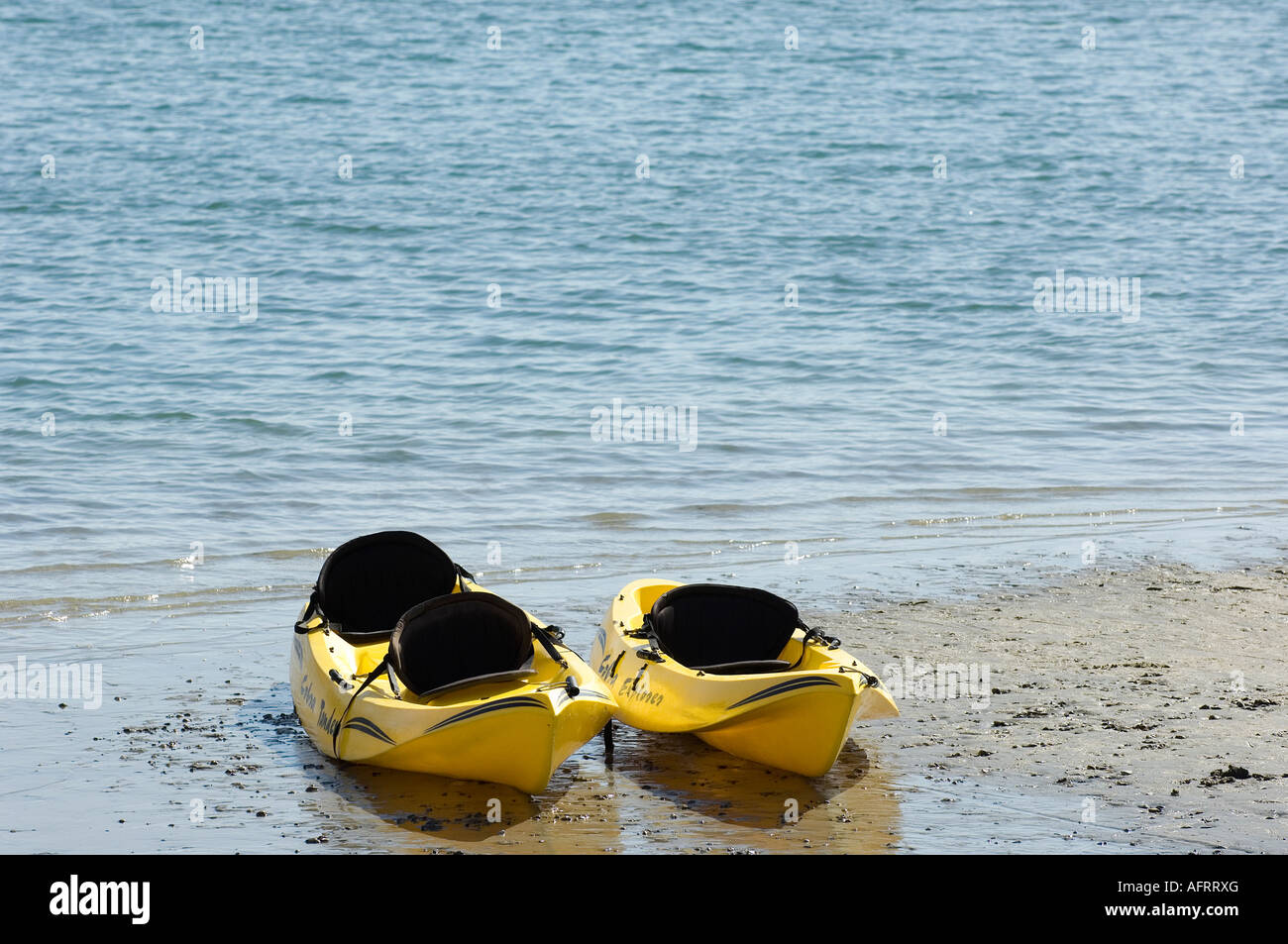 Two yellow kayaks on the beach Stock Photo - Alamy