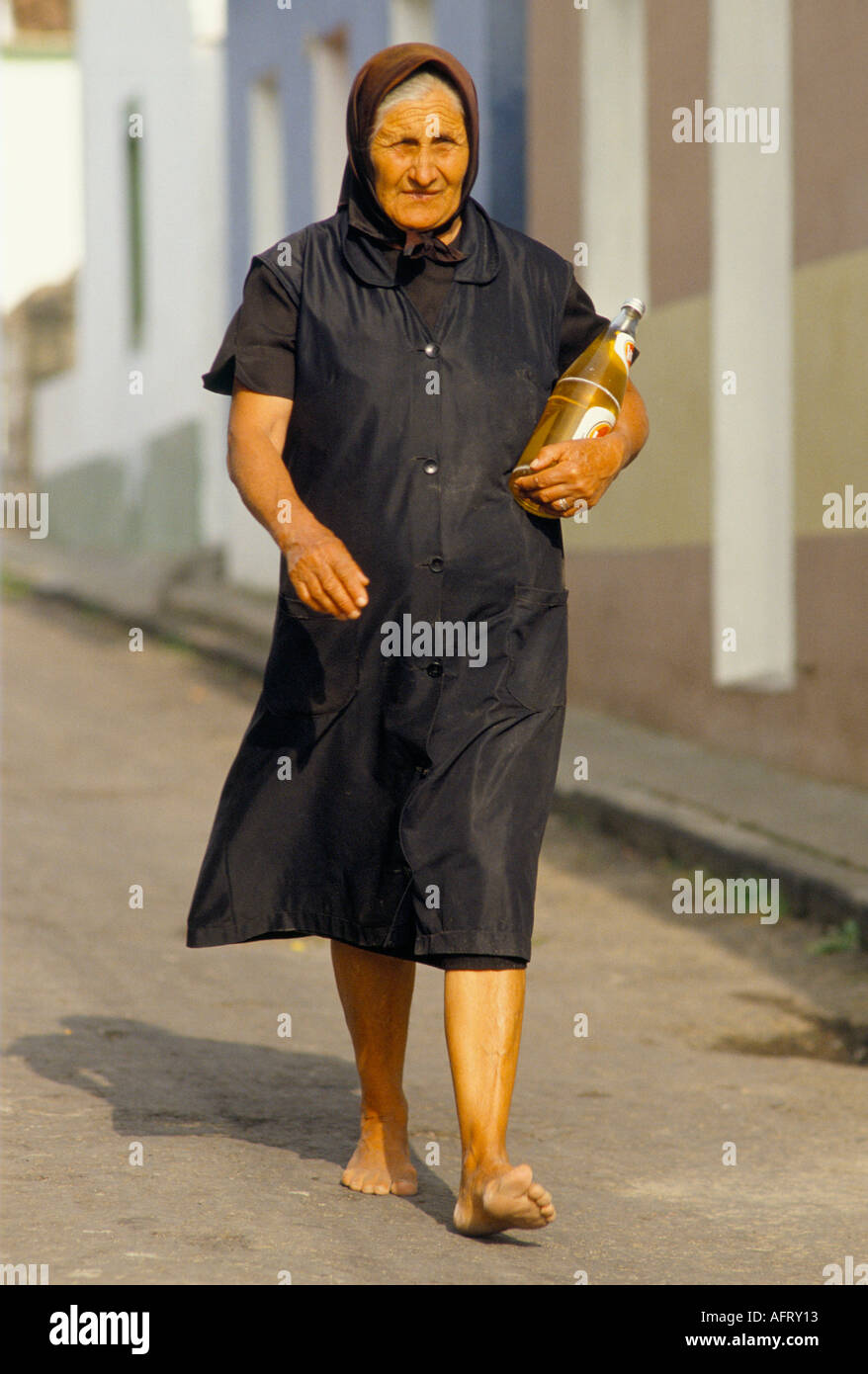 Woman walking bare feet, wearing no shoes. 1980s poverty in Europe. Sao ...