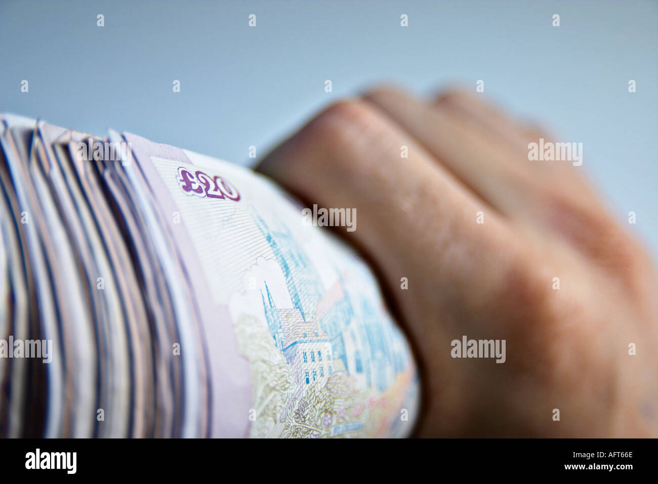 hand holding a wad of 20 pound notes cash Stock Photo - Alamy