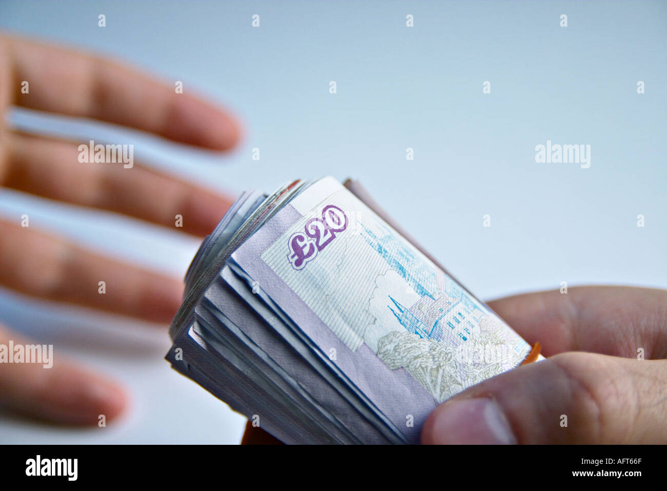 hand giving a wad of 20 notes cash pounds bribe bribery british uk ...