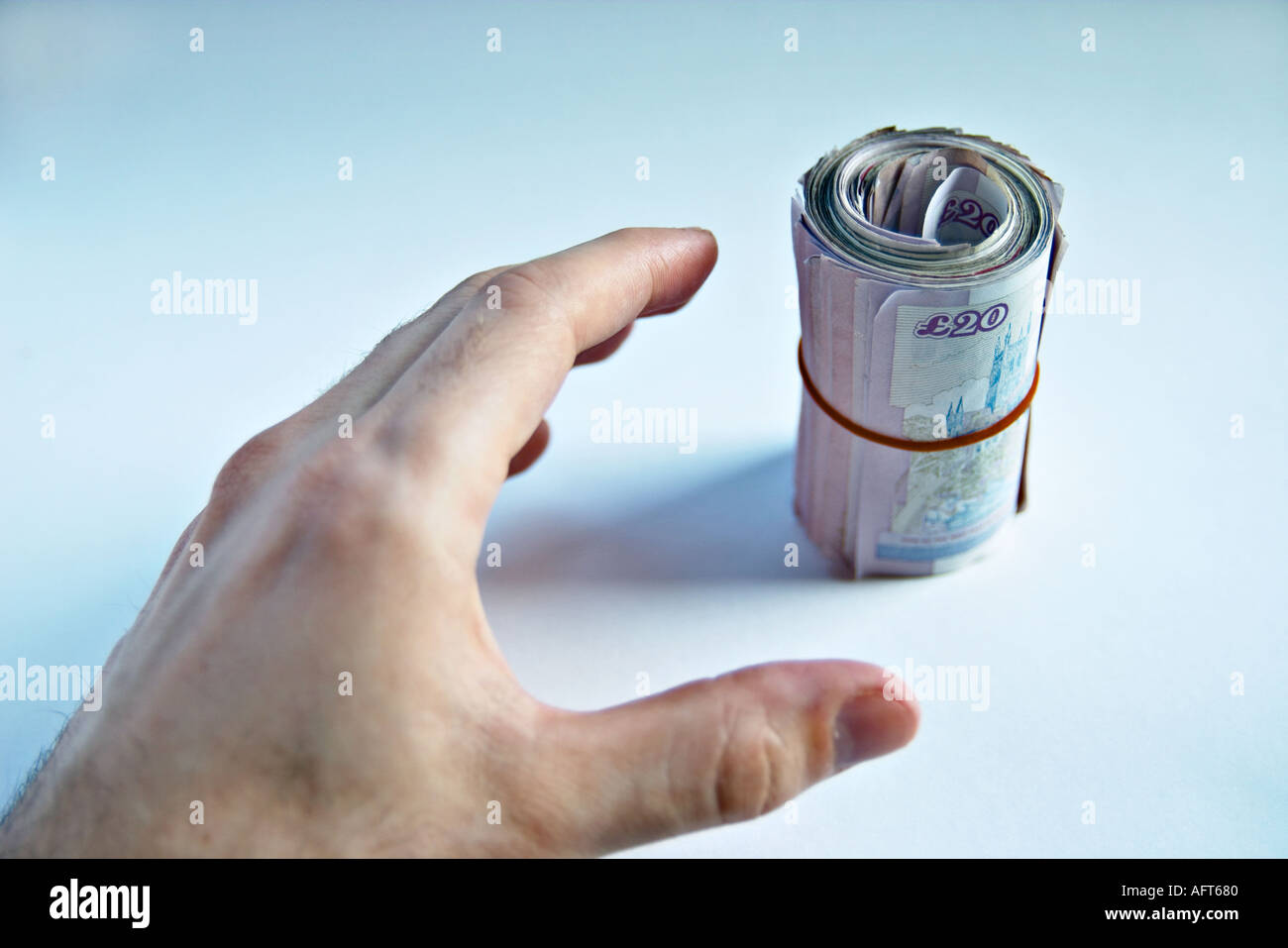 hand grabbing a wad of 20 notes cash pounds british uk sterling money ...