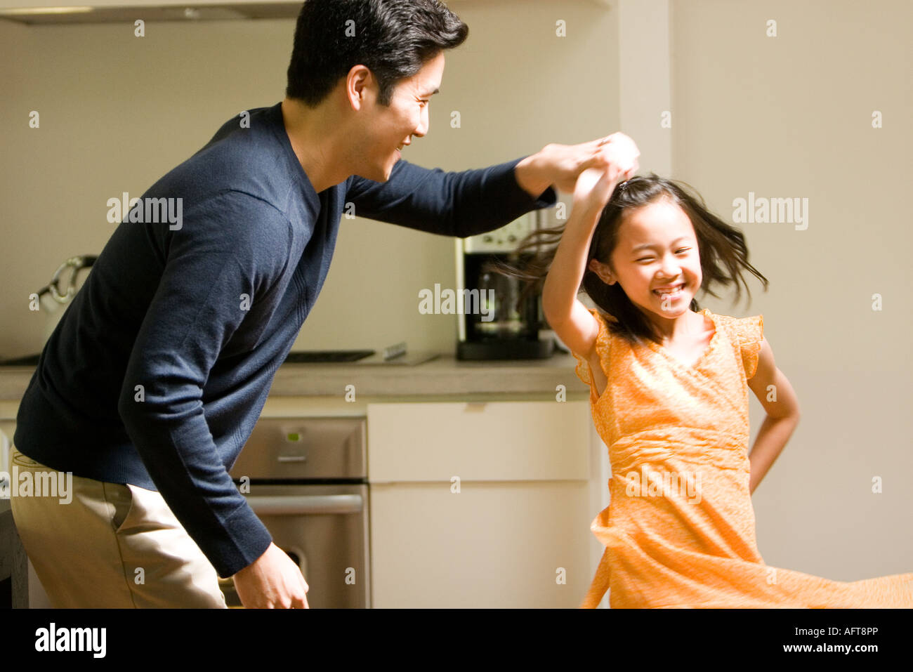 Father and Daughter Dance in the Kitchen of their Modern Home Stock ...