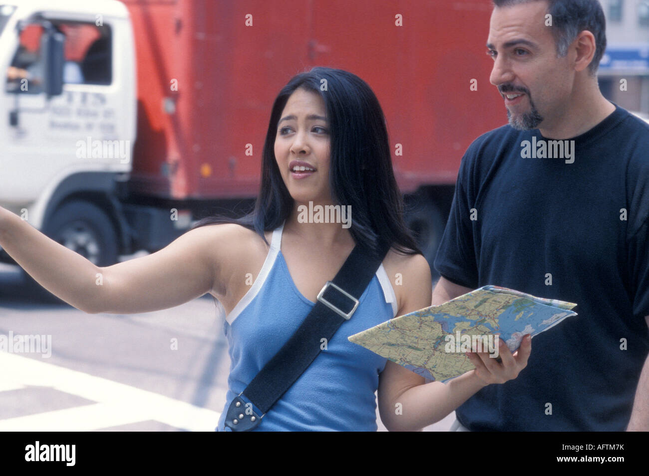 Young woman showing direction to man Stock Photo - Alamy