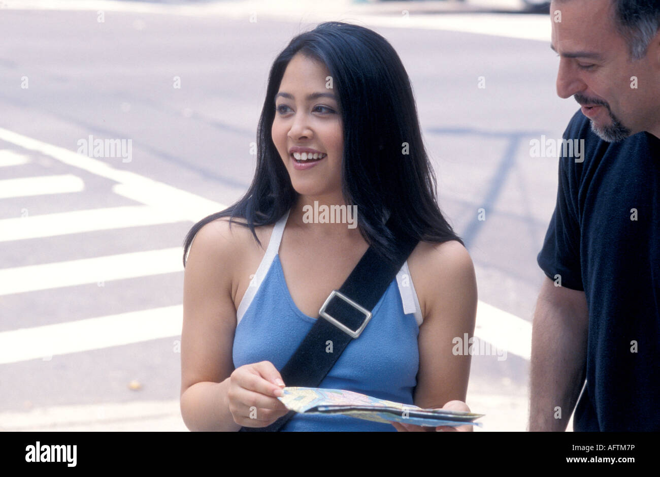 Young woman showing direction to man Stock Photo - Alamy