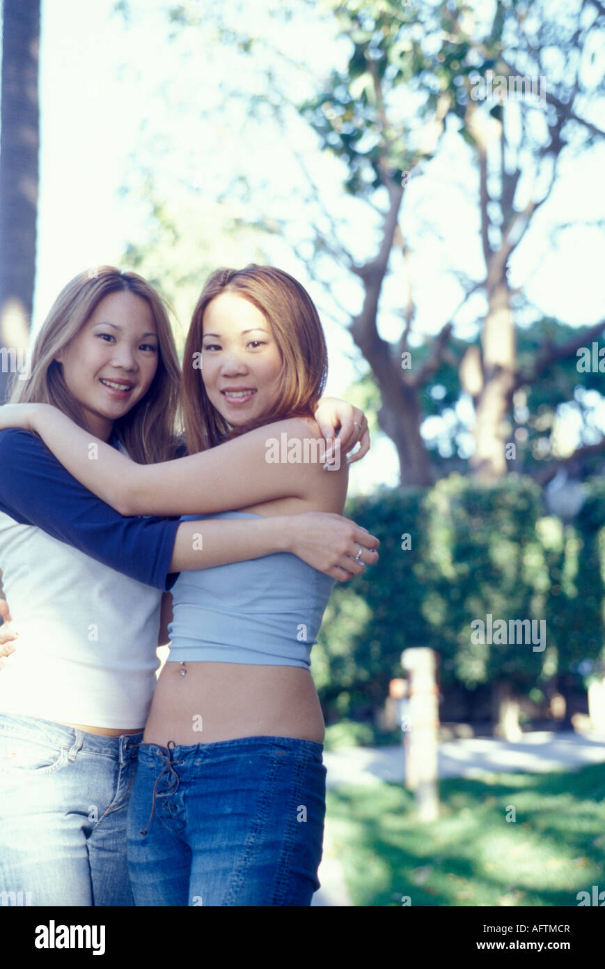 Friends embracing in street, portrait Stock Photo - Alamy