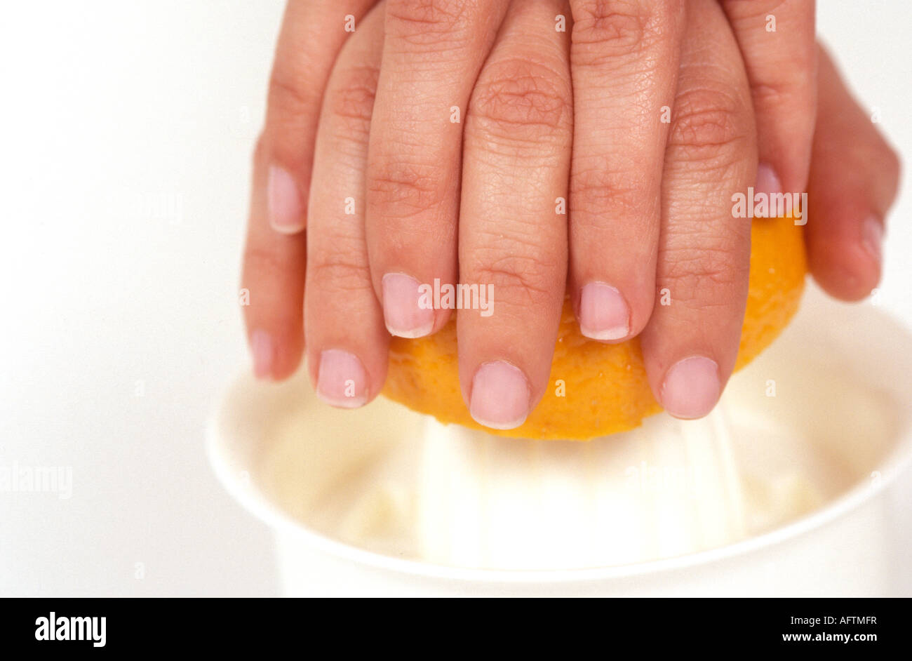 Hands with citrus fruit on juice reamer, close up Stock Photo - Alamy