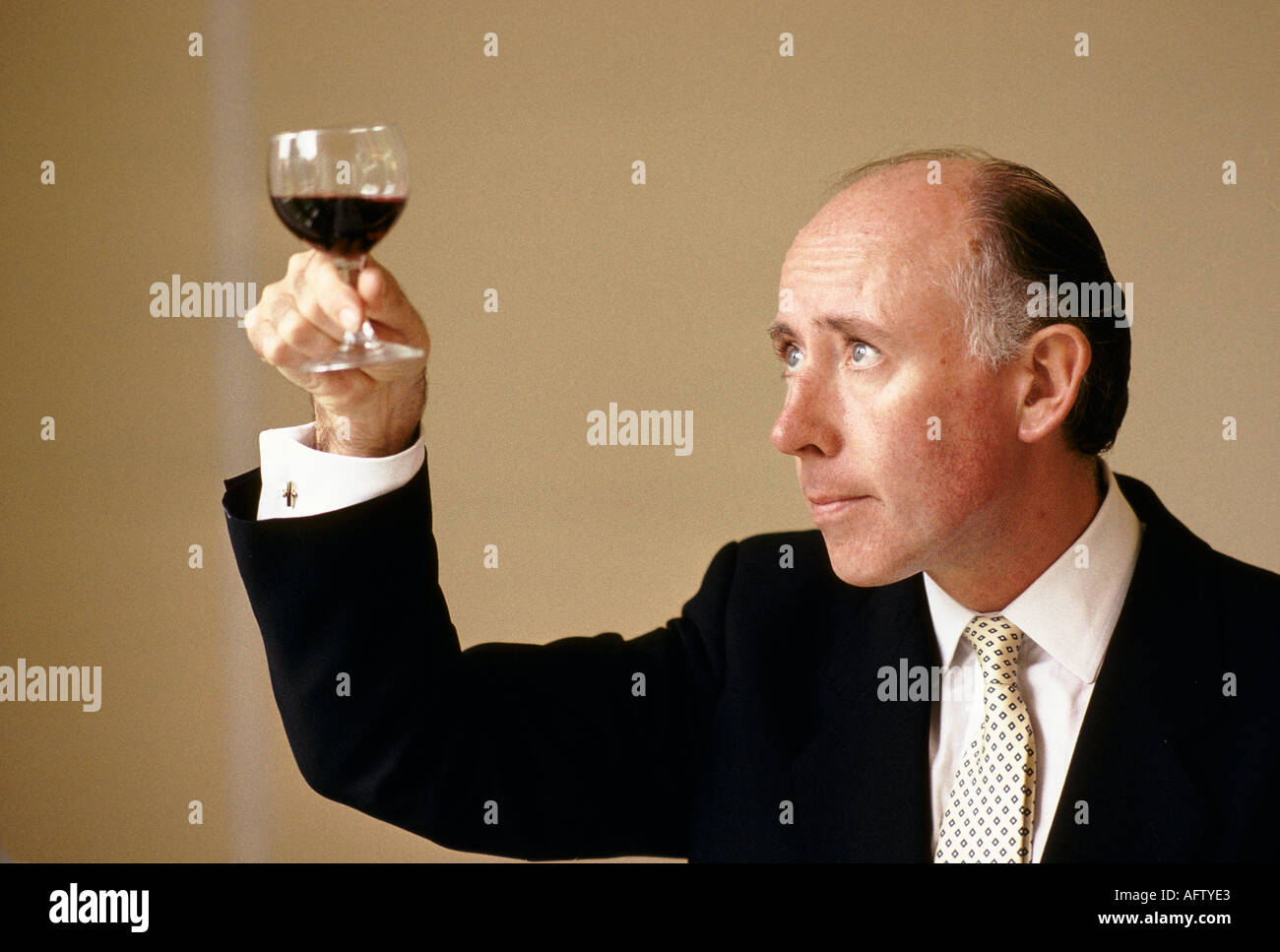English wine competition, judge judging the colour of a red wine ...