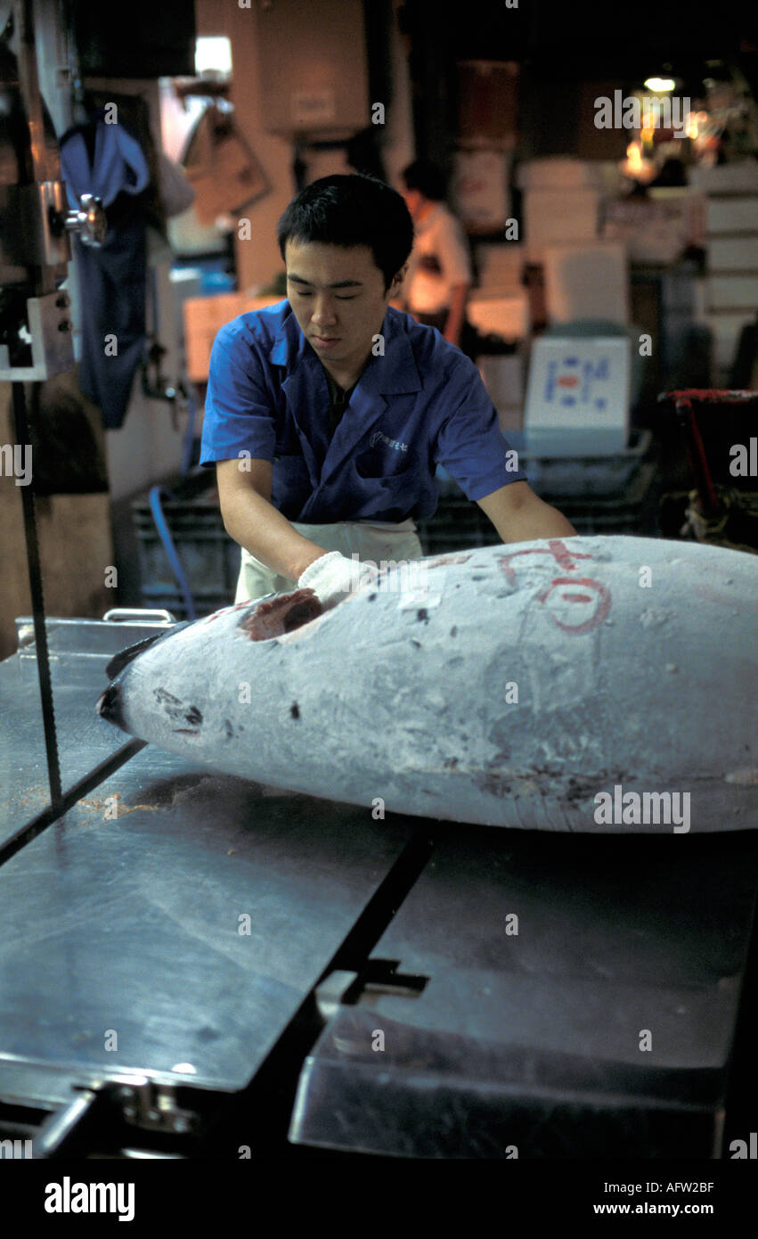 Japanese fishmonger cutting frozen bluefin tuna fish at Tsukiji Fish ...