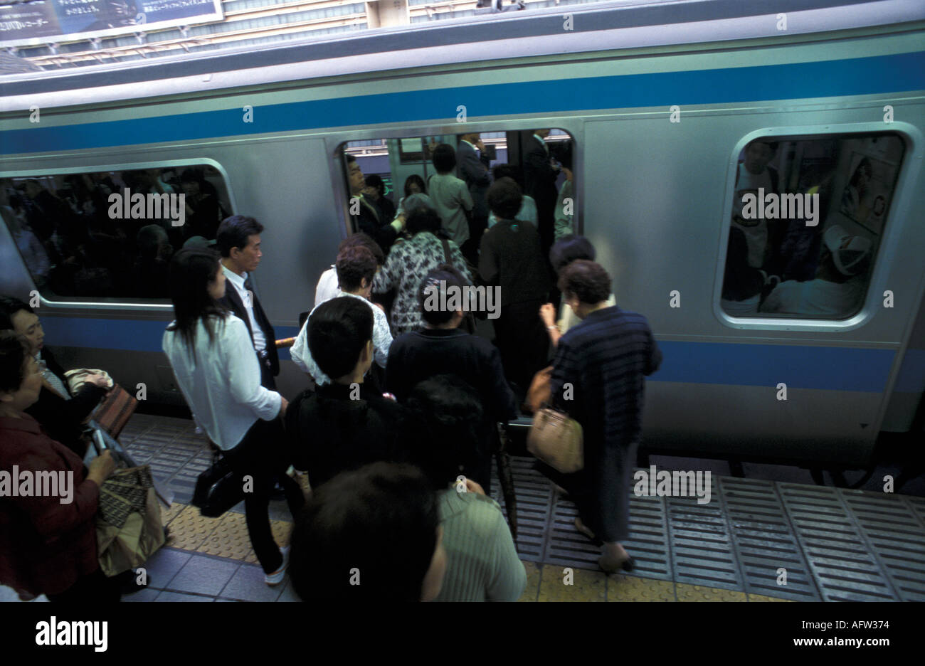 Japanese people getting on subway train in Tokyo Japan Stock Photo - Alamy