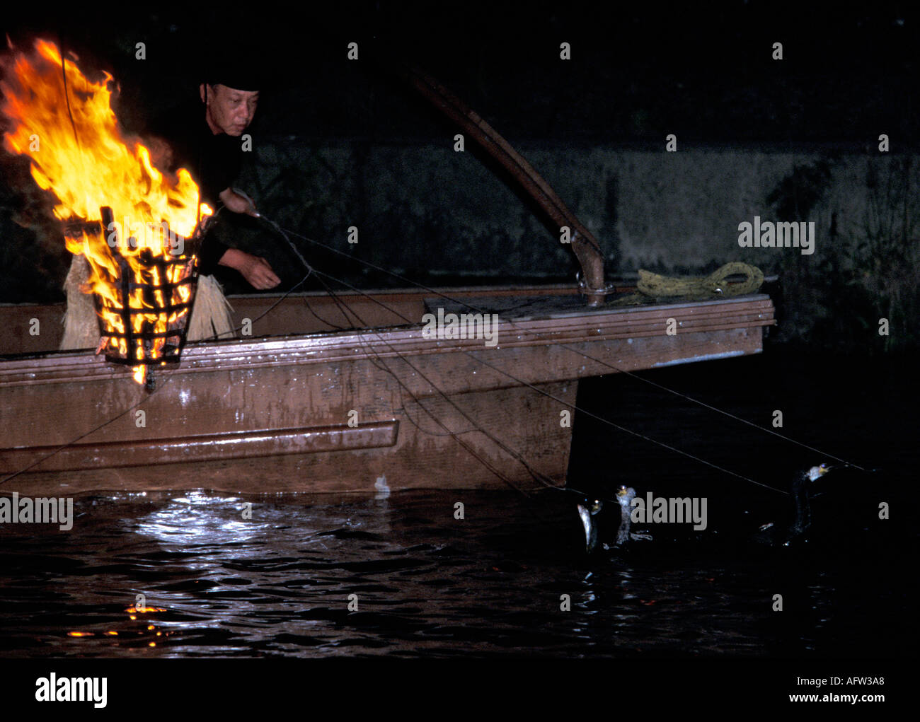 Japanese fisherman in traditional costume on torch lit boat with ...