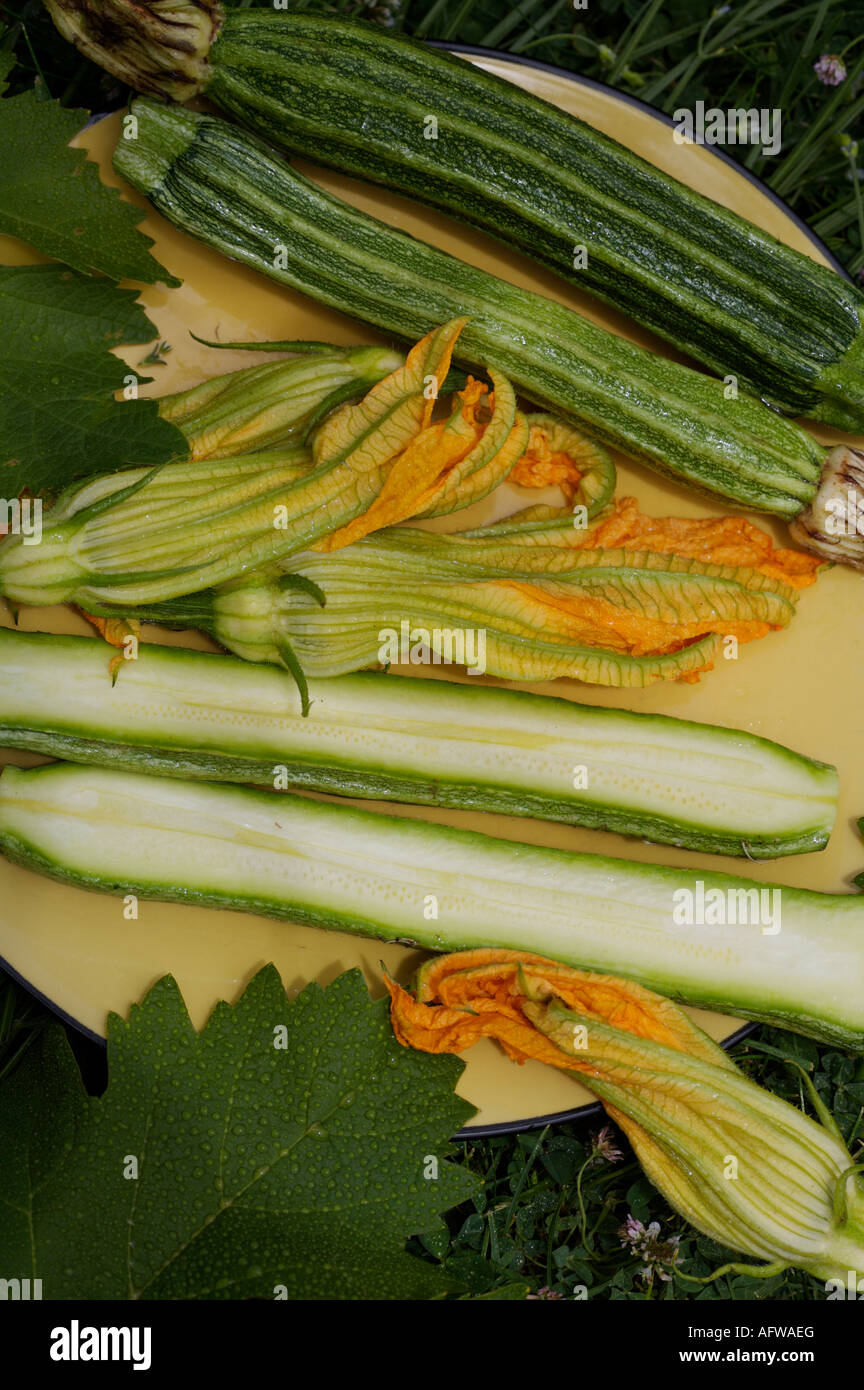 Close up of courgettes sliced lengthways and whole with their flowers ...