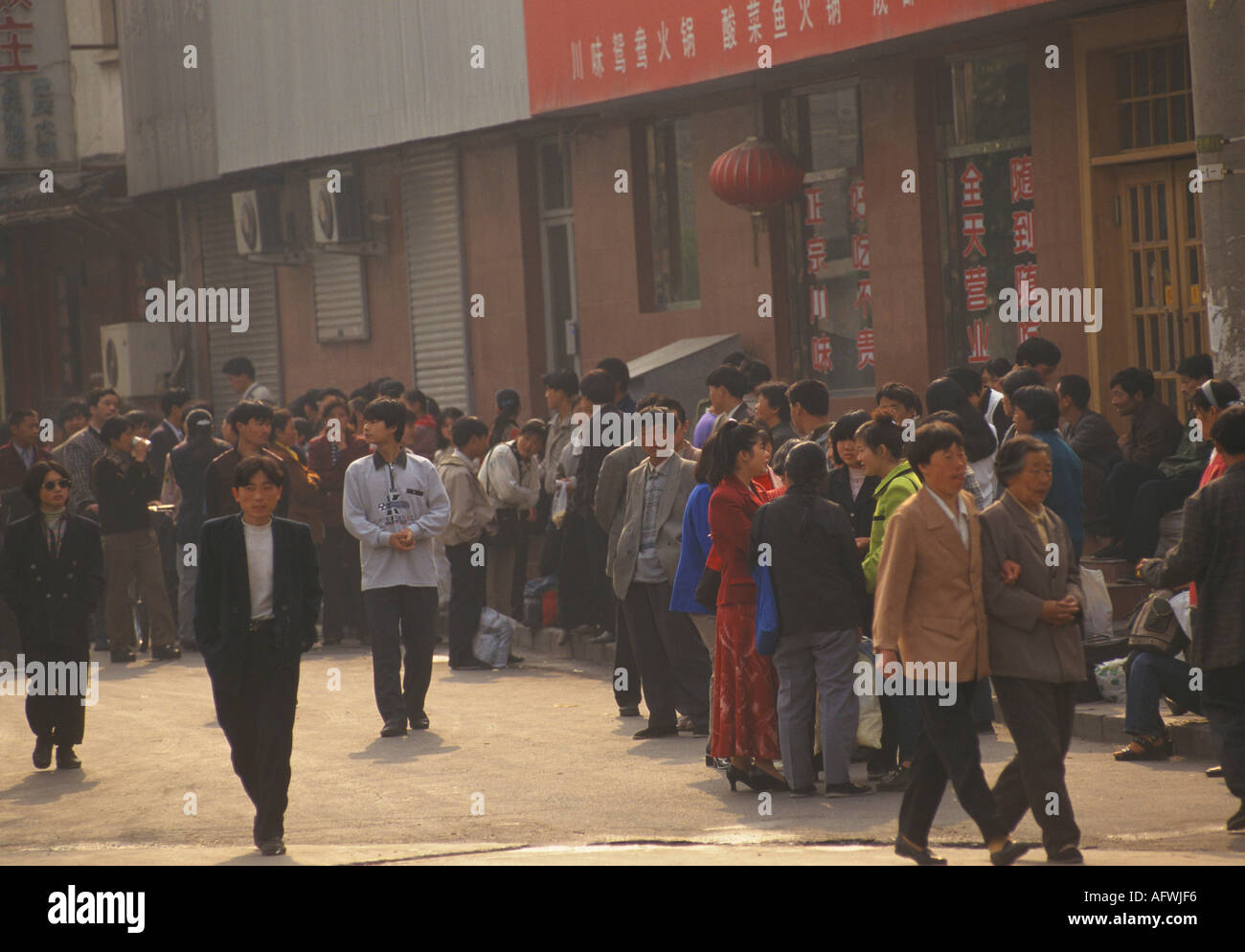 China 1990s Beijing. Migrant labour force workers wait for their trains ...
