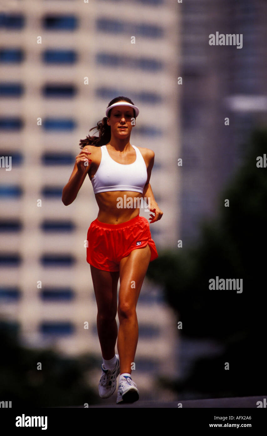 A woman runs in the midst of urban high rise buildings Stock Photo - Alamy