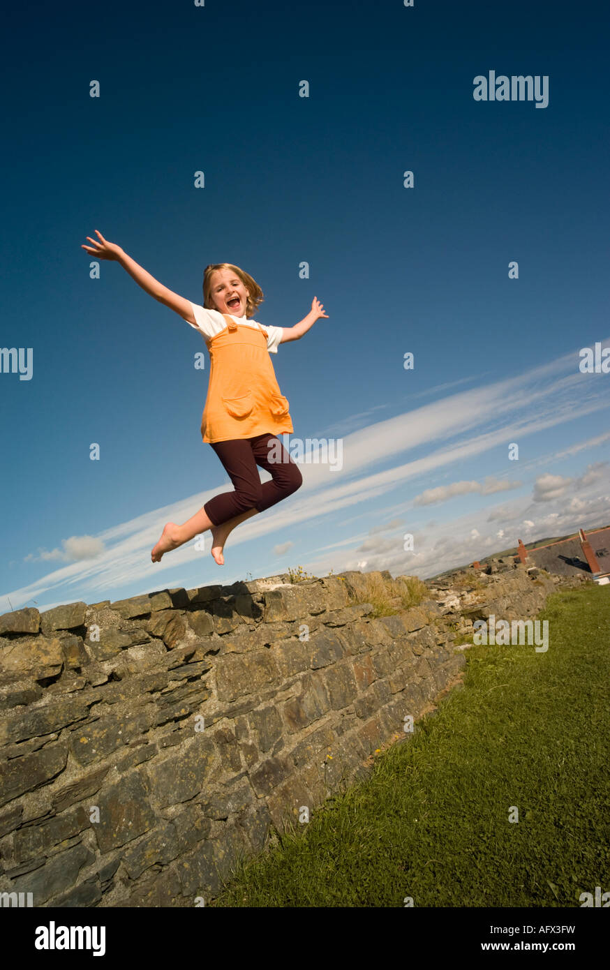 eight year old girl child leaping in the air with joy fun excitement ...