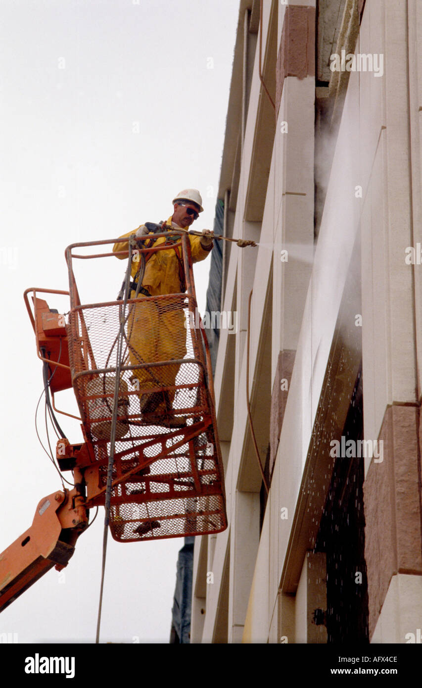 construction worker spraying side of building Stock Photo - Alamy