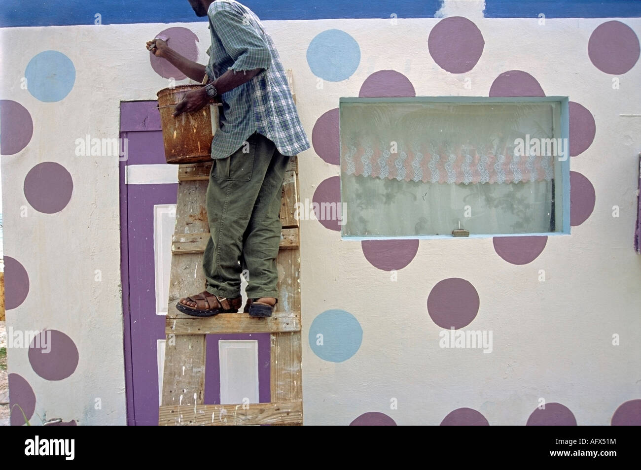 Bahamian man in front of his colorfully painted home in Governors ...