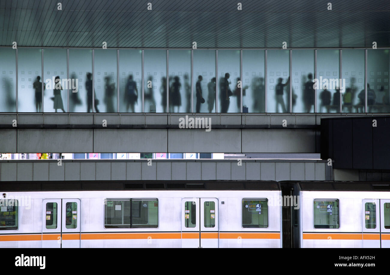 A line of commuters behind a window at Shibuya station in Tokyo with a ...