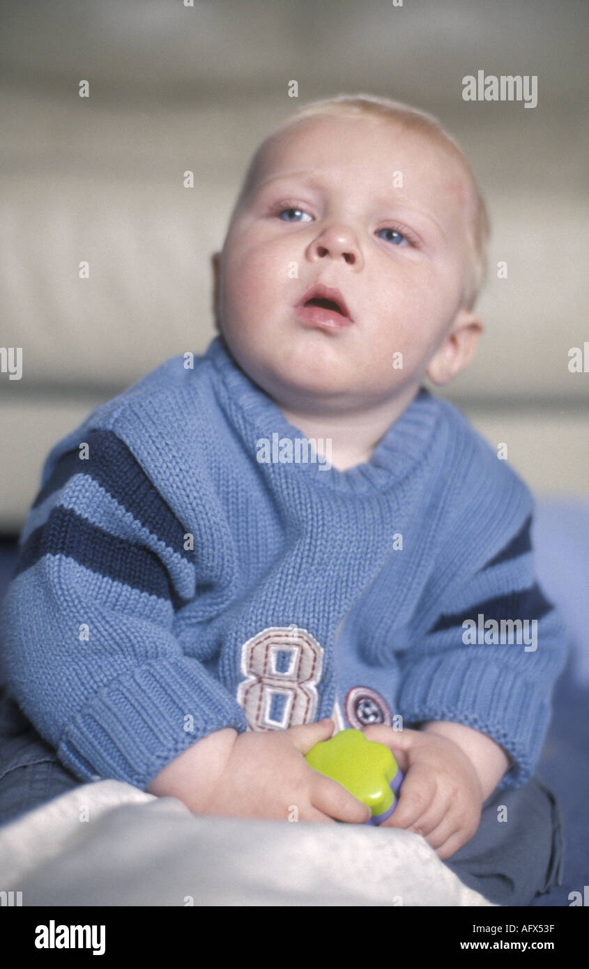 Twelve months old baby temporarily distracted from toys Stock Photo - Alamy