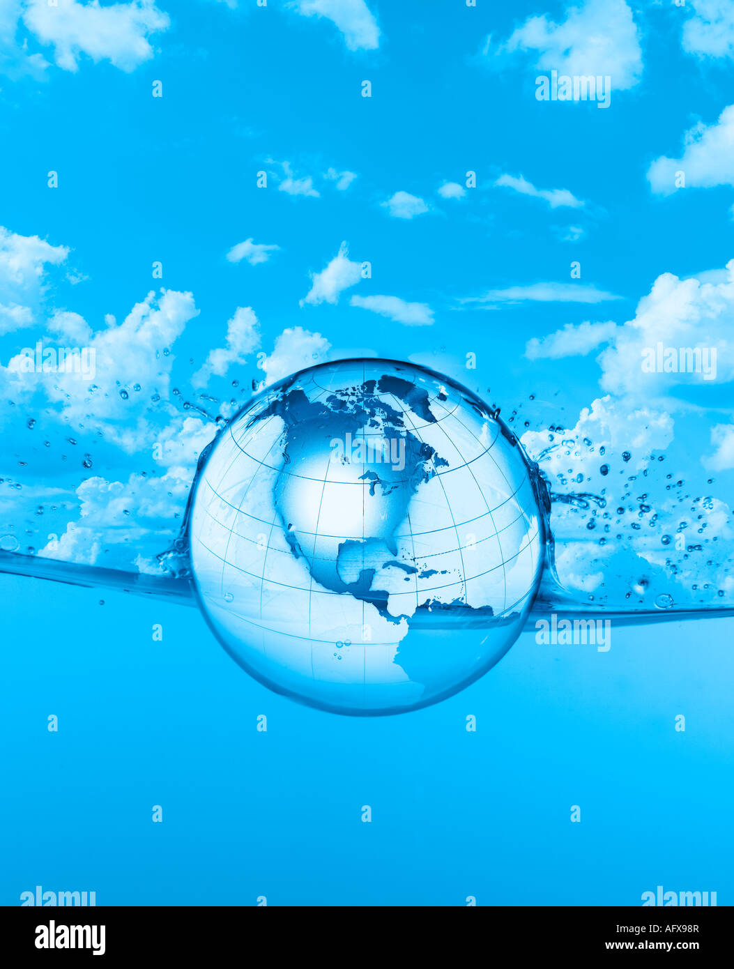 Globe sinking into water Stock Photo - Alamy