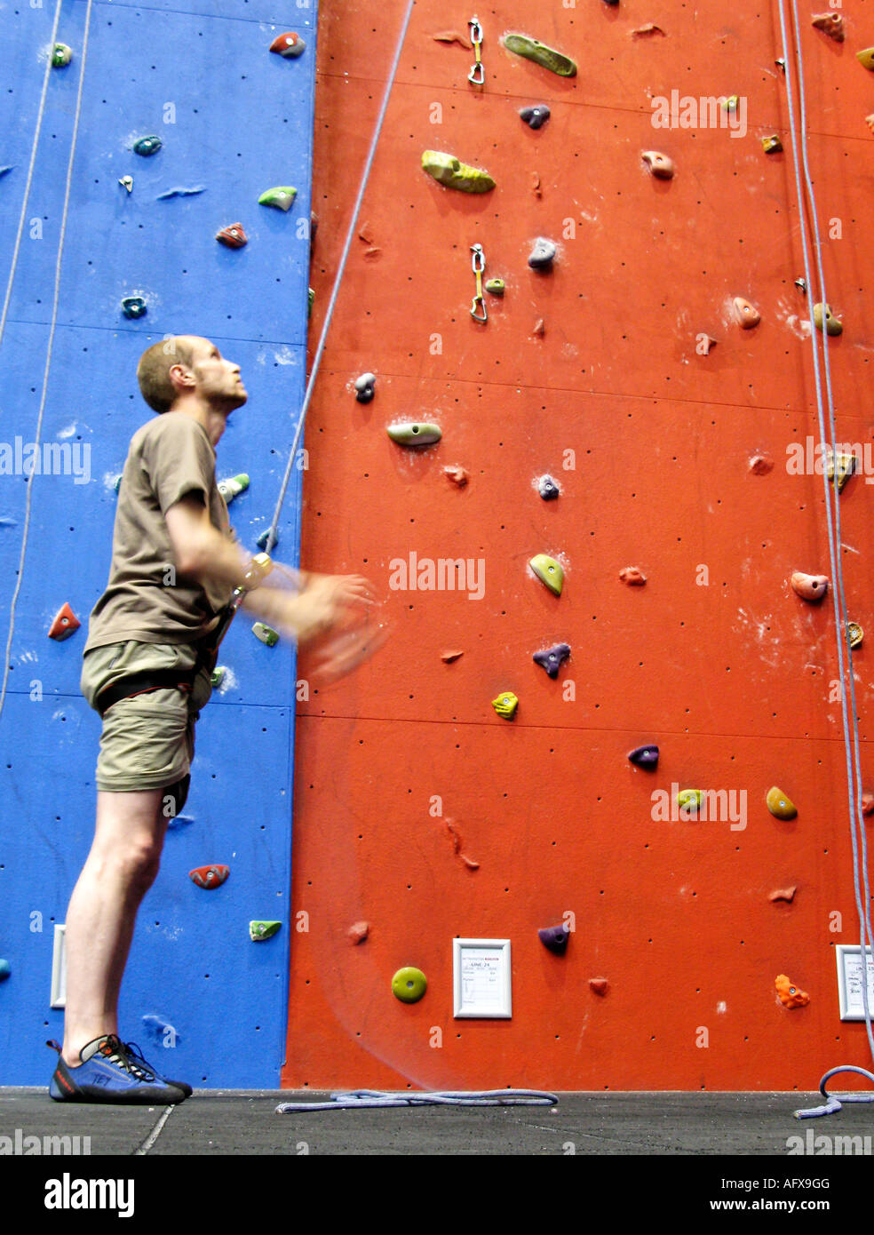 A single white male preparing to climb an indoor climbing wall route ...