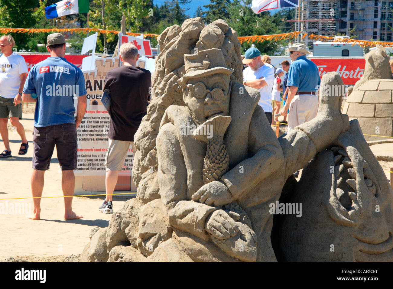 sandcastle man holding fish fighting shark Stock Photo - Alamy