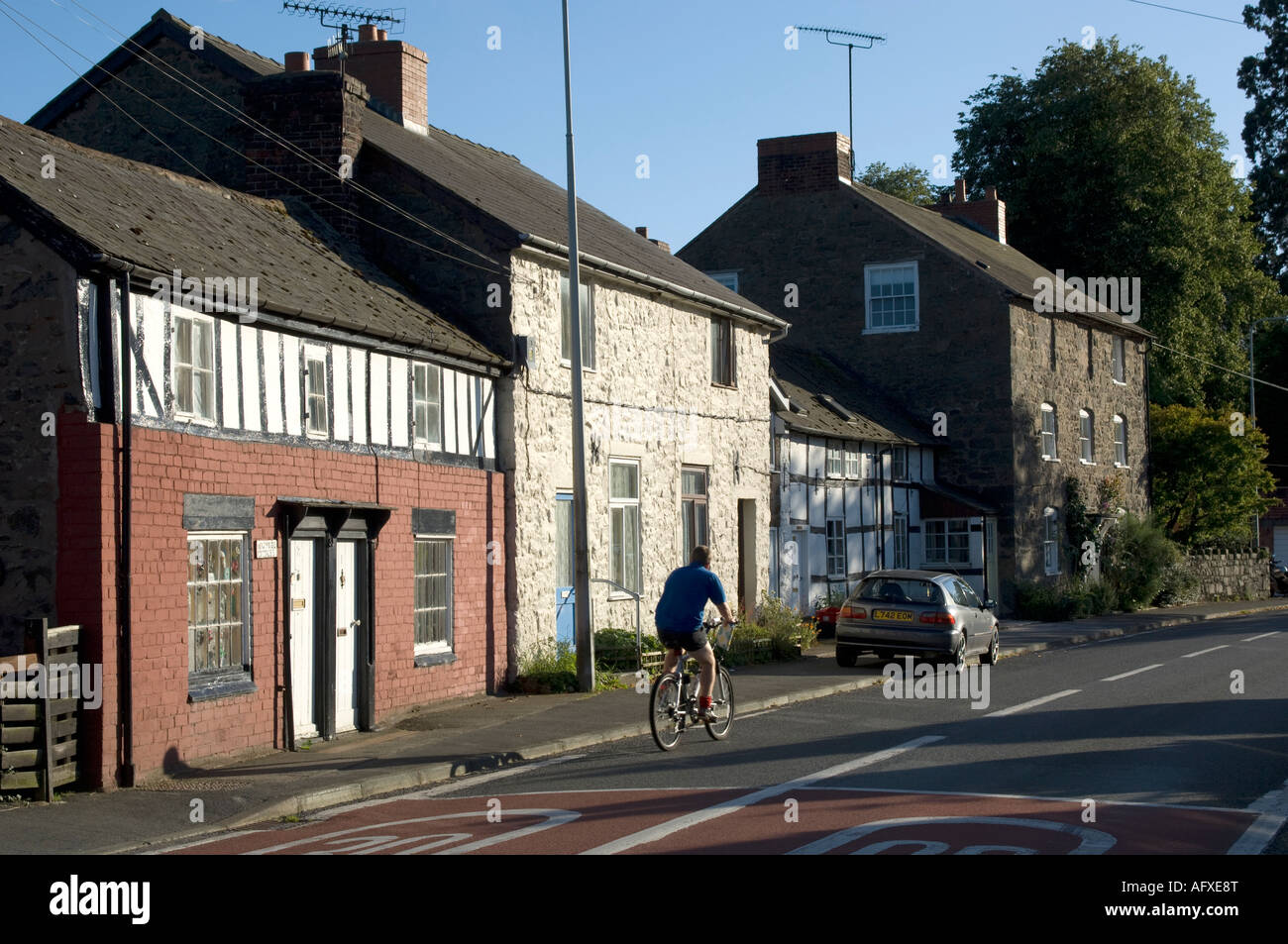 man on bike cycling through Meifod village Powys mid wales on a summer ...